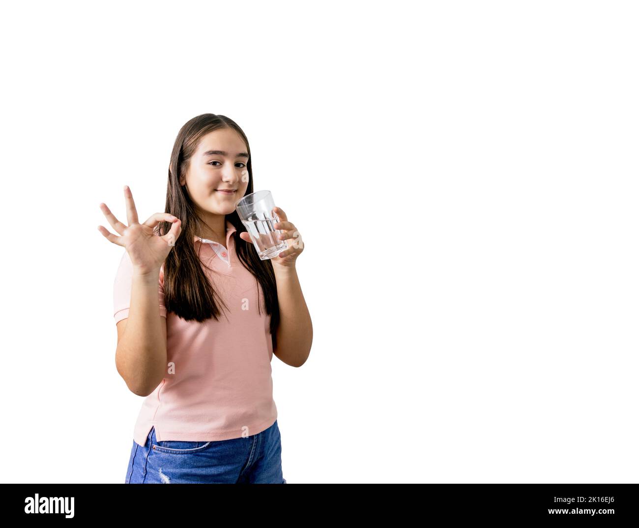 A young Hispanic lady drinking water while showing ok hand gesture ...