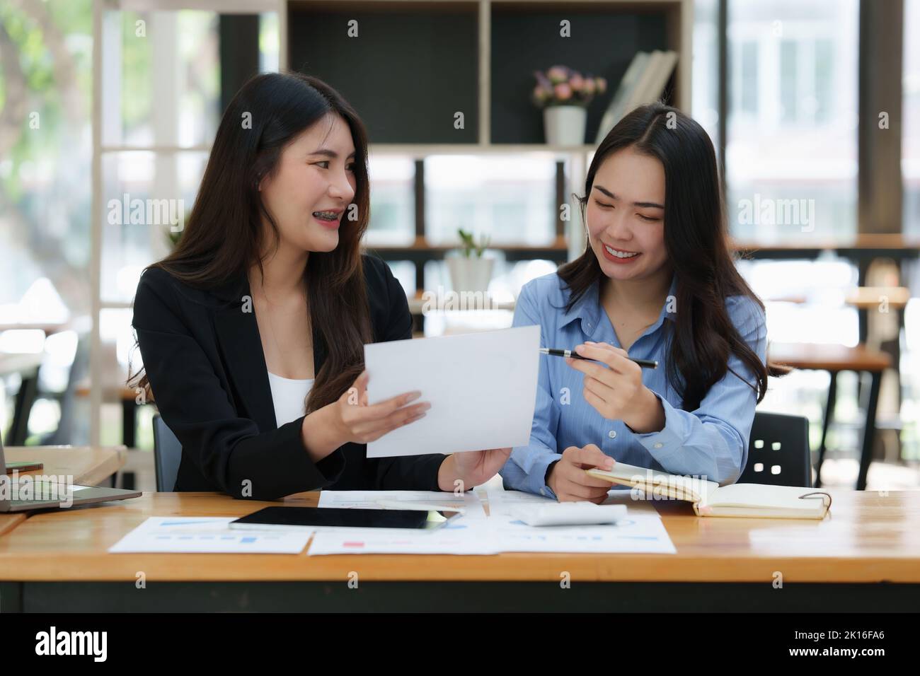 Asian Business Woman or Accountant do math and analyze with calculator ...