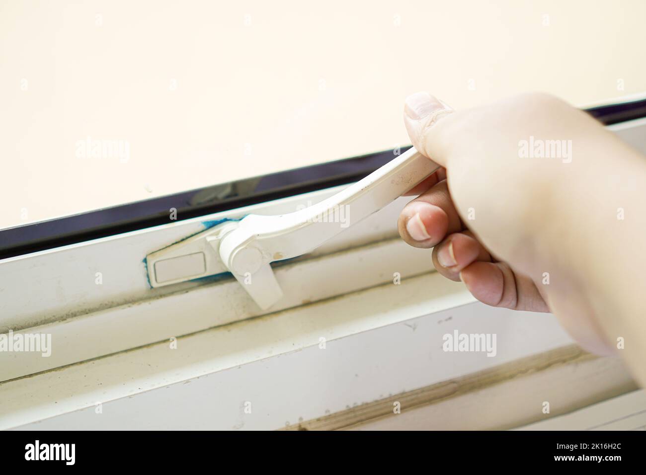 human hand on plastic window lock handle Stock Photo - Alamy