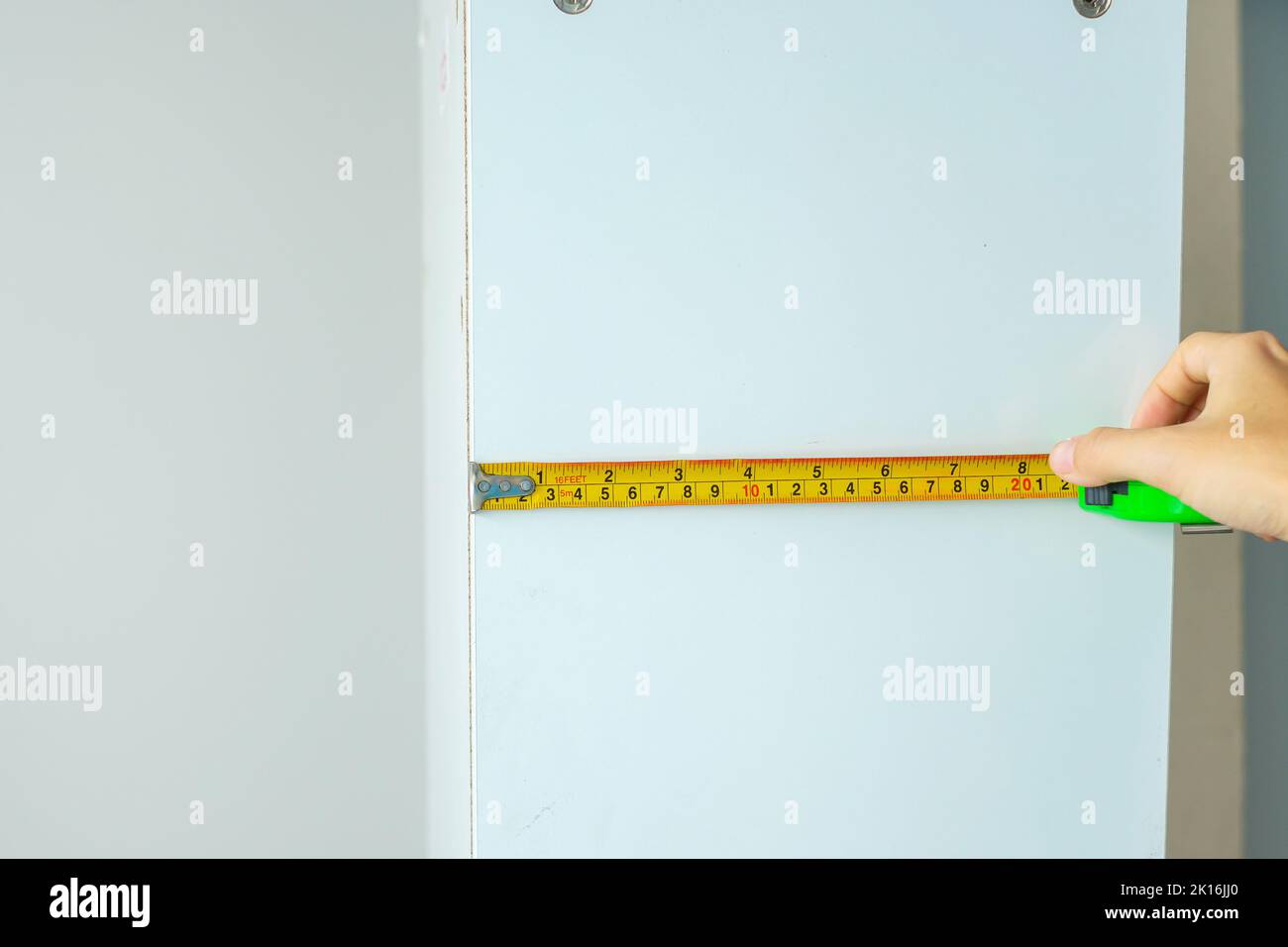Man hand using tape measure for measuring furniture at home. DIY ...