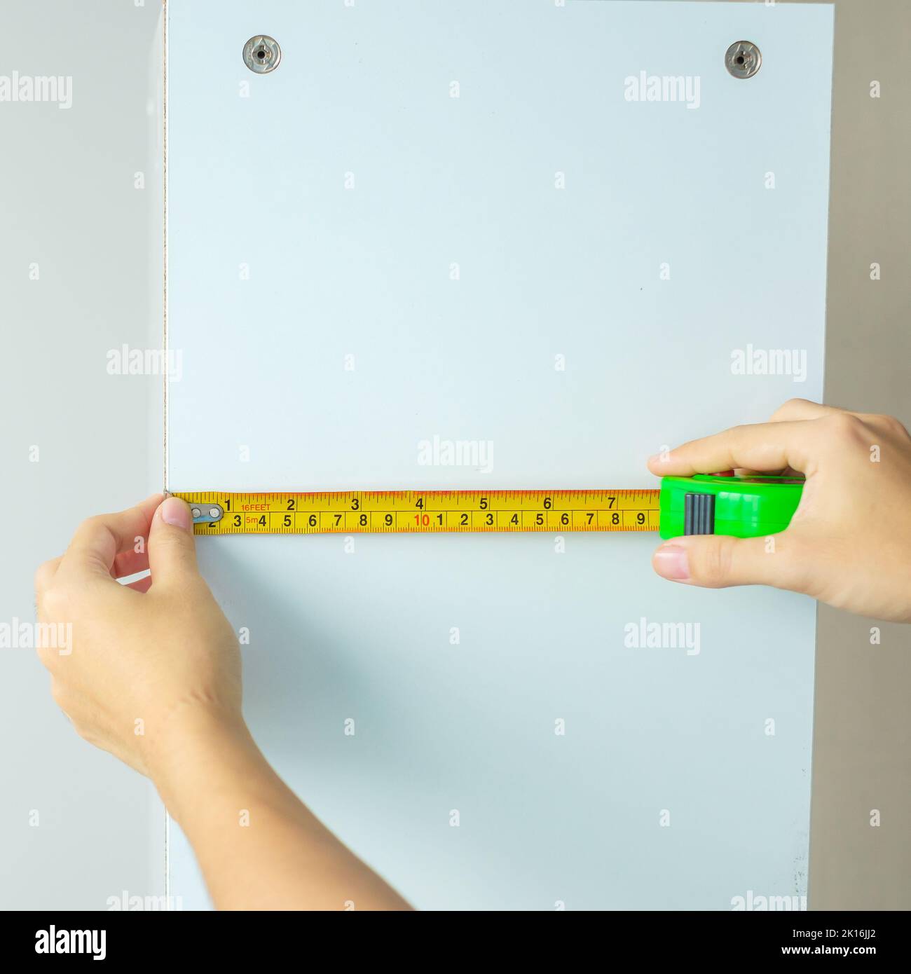 Man hand using tape measure for measuring furniture at home. DIY ...