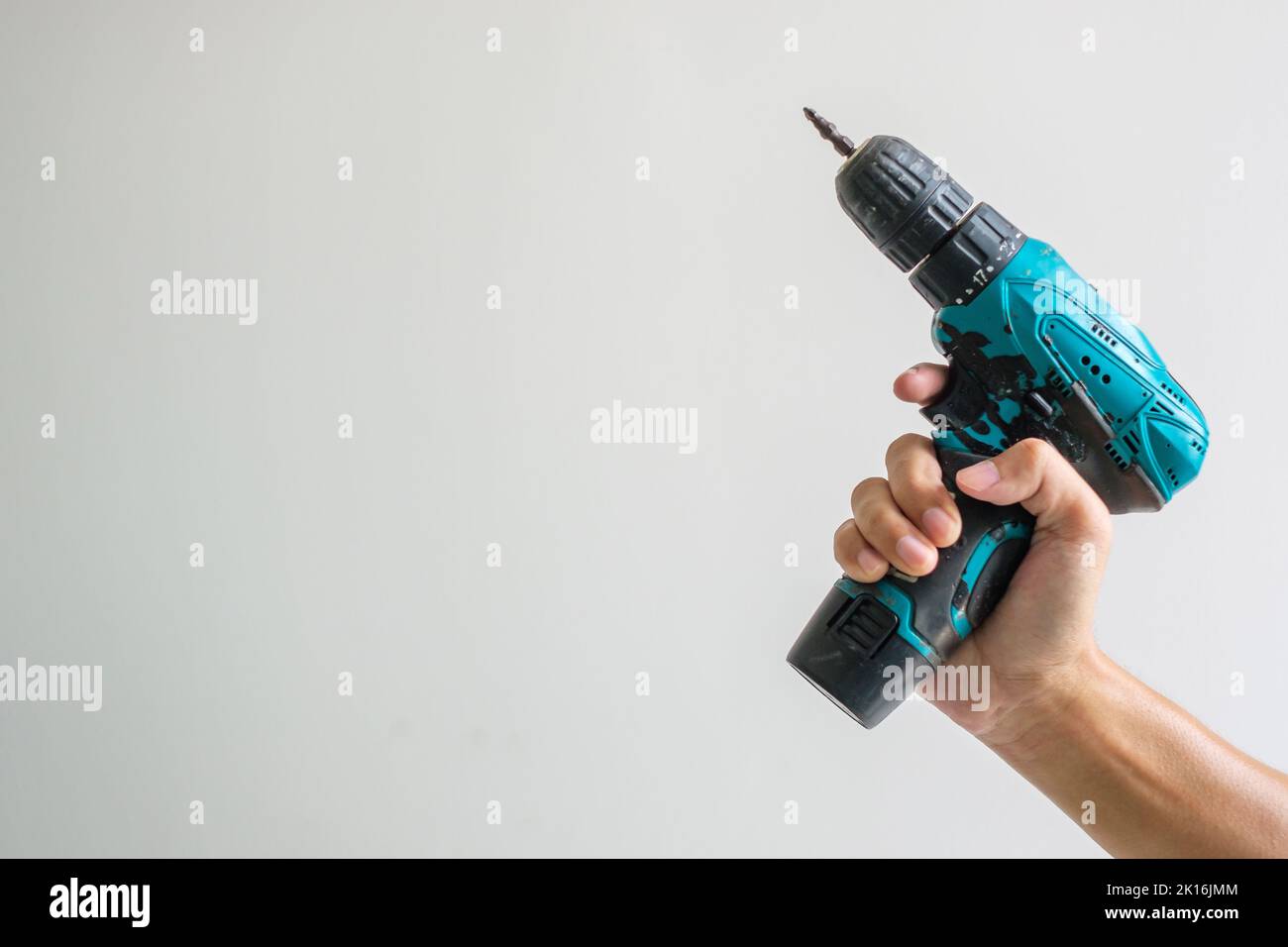 man hand holding cordless screwdriver with wall background, Carpenter ...