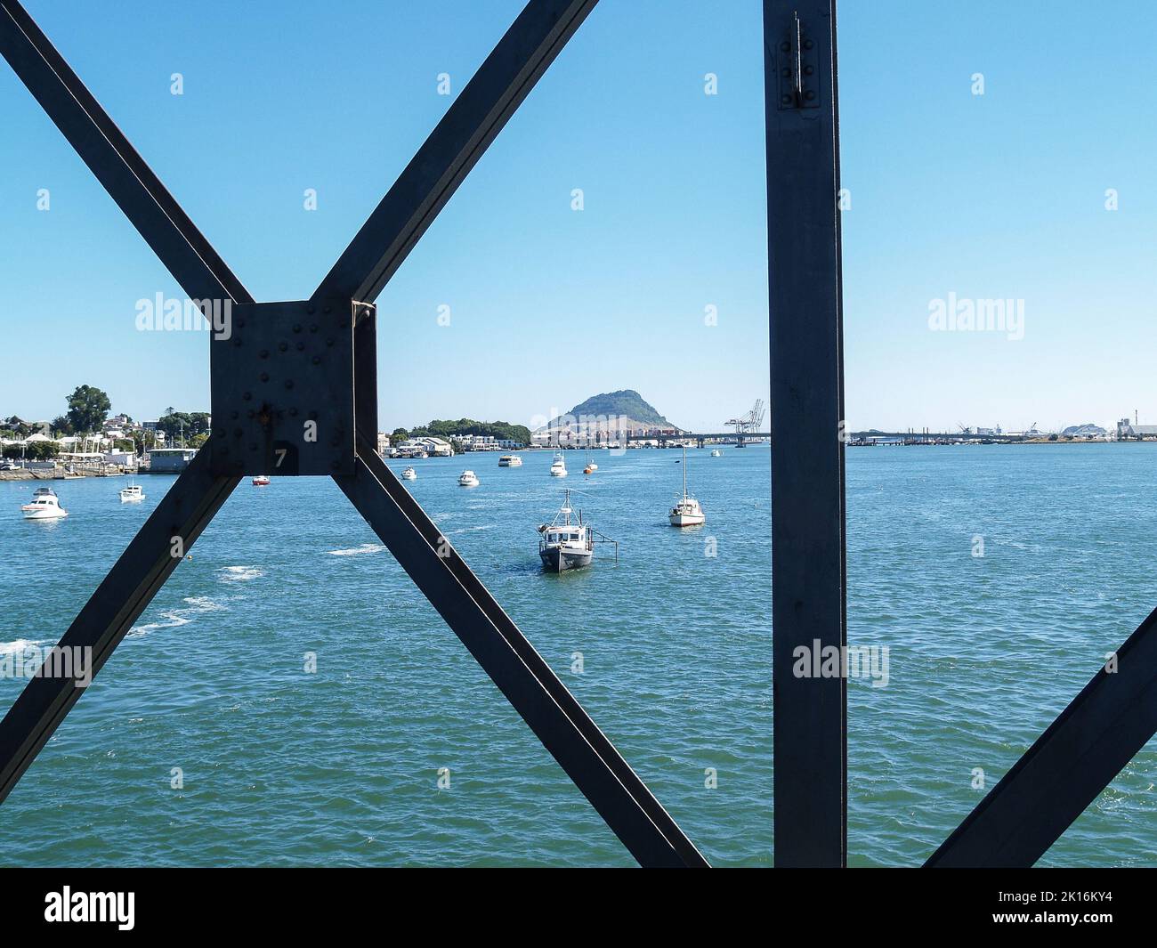 View of Tauranga Harbour through structural pattern of steel bridge ...