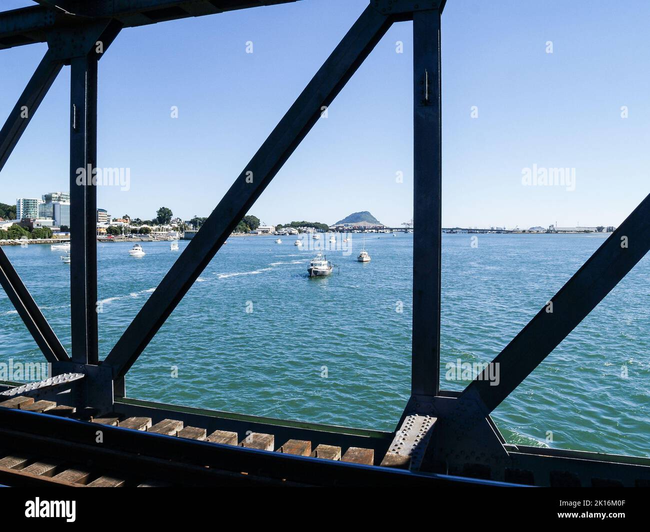 View of Tauranga Harbour through structural pattern of steel bridge ...