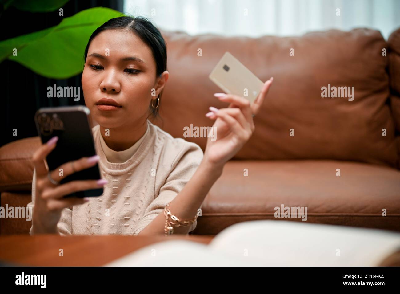 Gorgeous millennial Asian female using a mobile banking application to ...