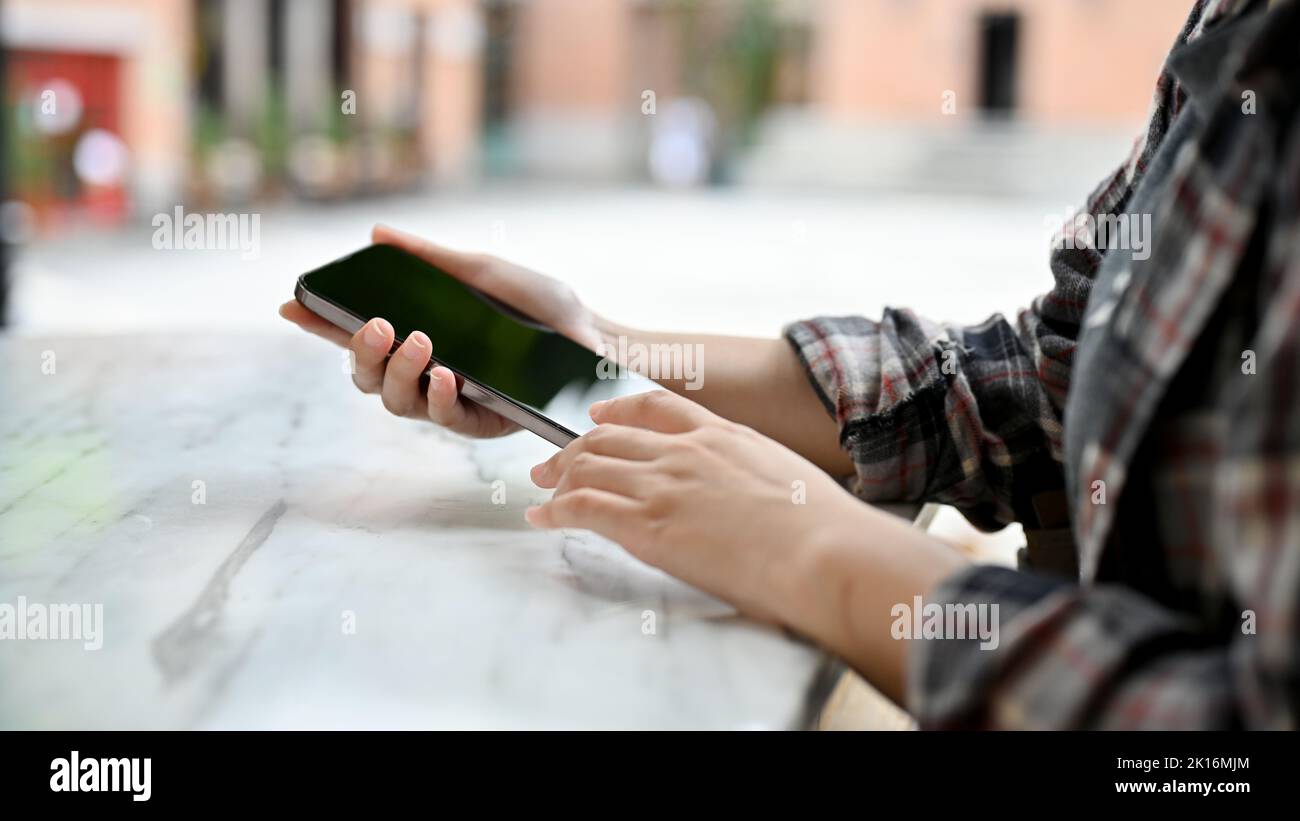 A female uses her smartphone to chat with her friends while sitting ...