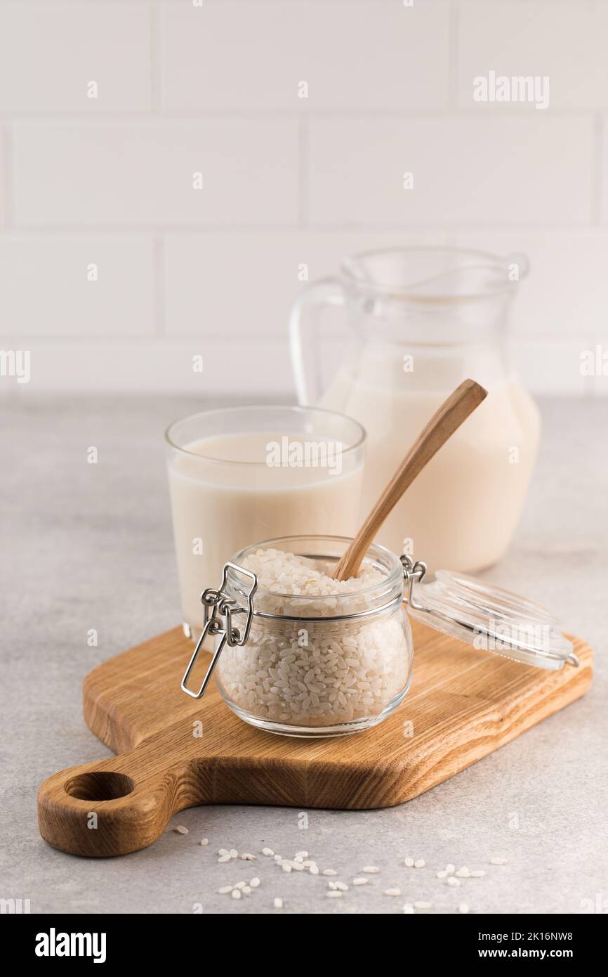 A jar of raw rice and rice milk in a glass on a plank. Healthy food ...
