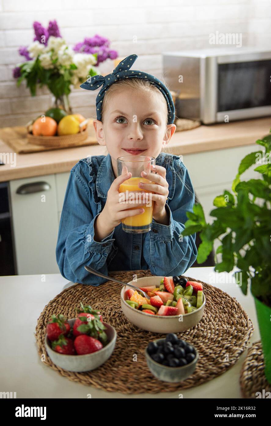 Healthy food at home. Cute little girl eats fruit salad Stock Photo - Alamy