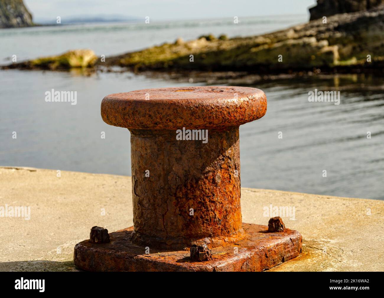 Rusty bollard on the quayside at Ballintoy for the fishing boats to tie ...