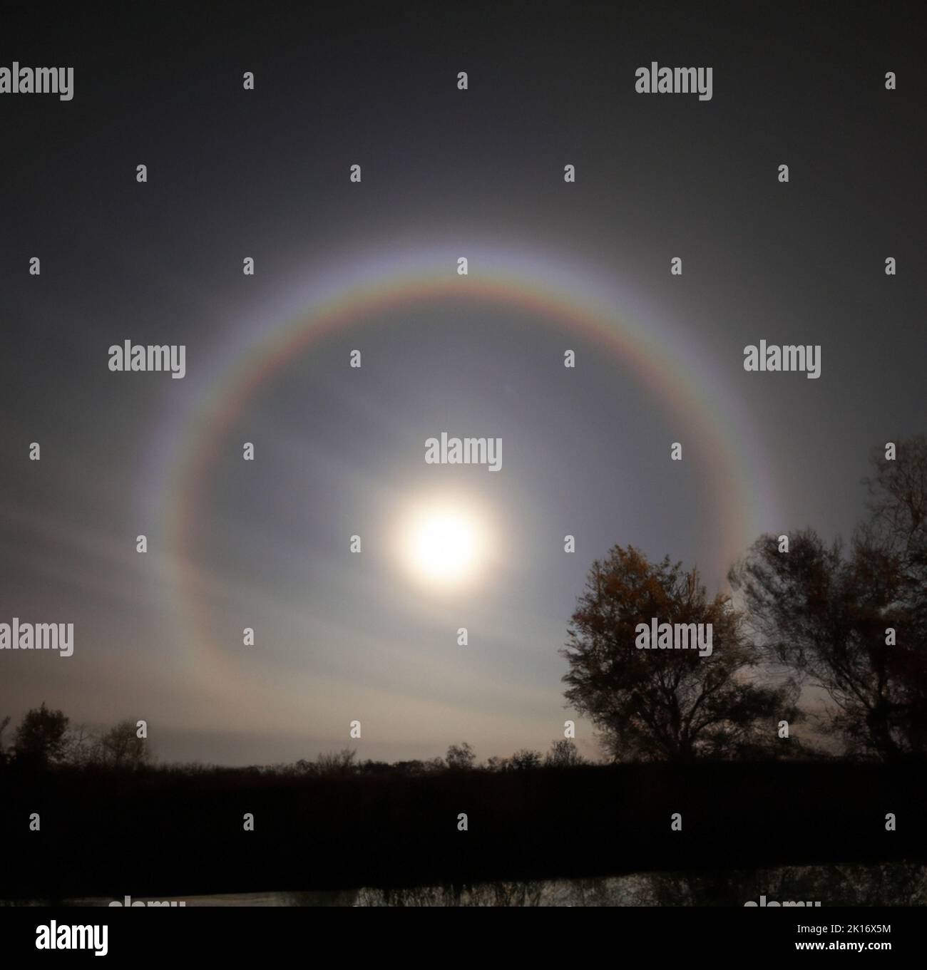 A moonbow and a shining full moon in a clear gray sky Stock Photo - Alamy