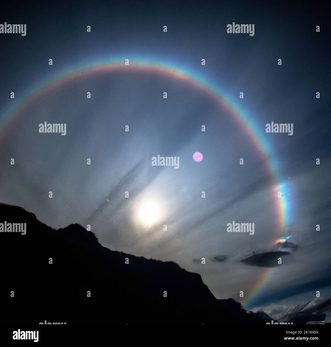 A Moonbow and a shining full moon in a clear gray sky Stock Photo - Alamy