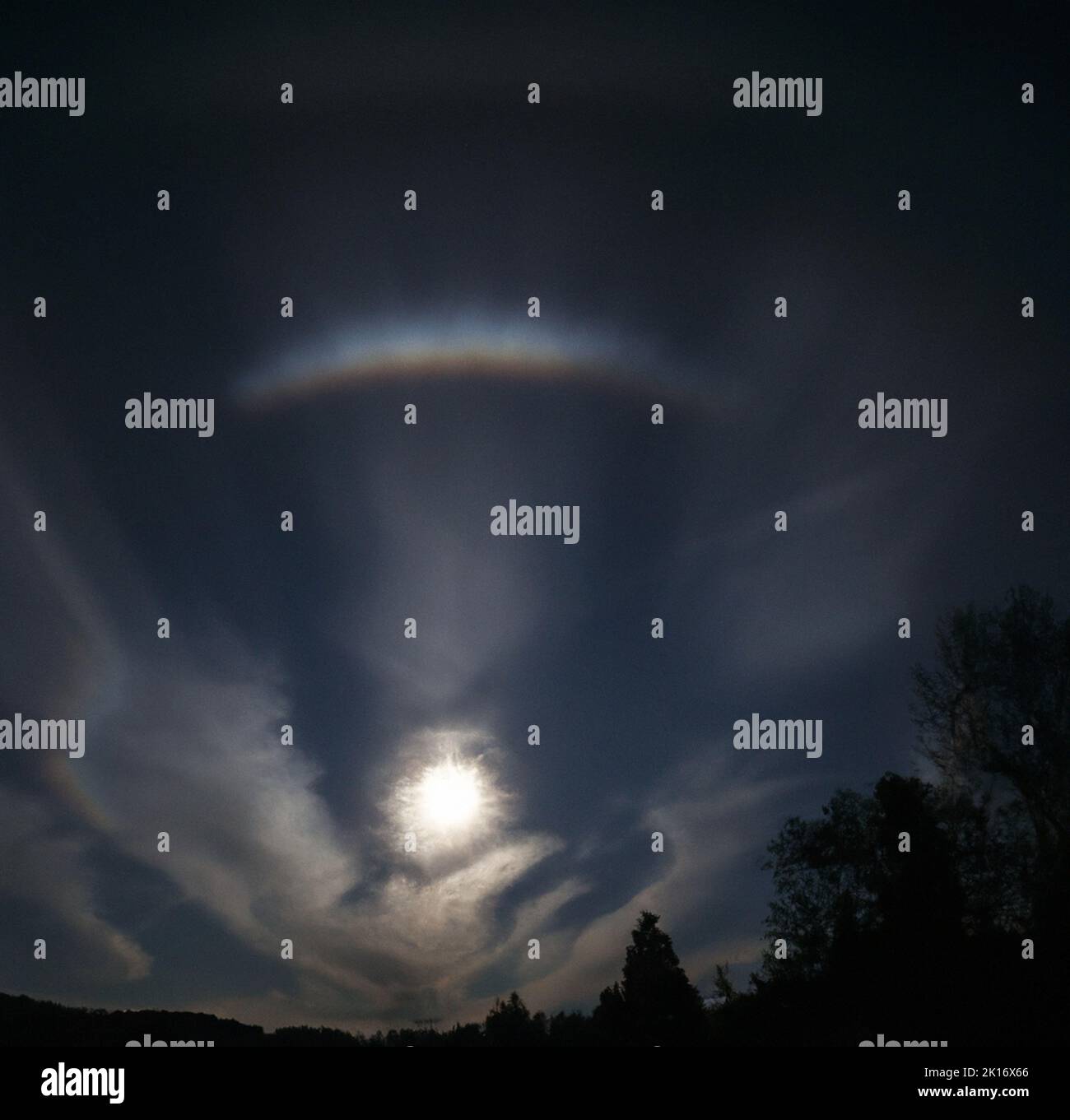 A Moonbow and a shining full moon in a clear gray sky Stock Photo - Alamy