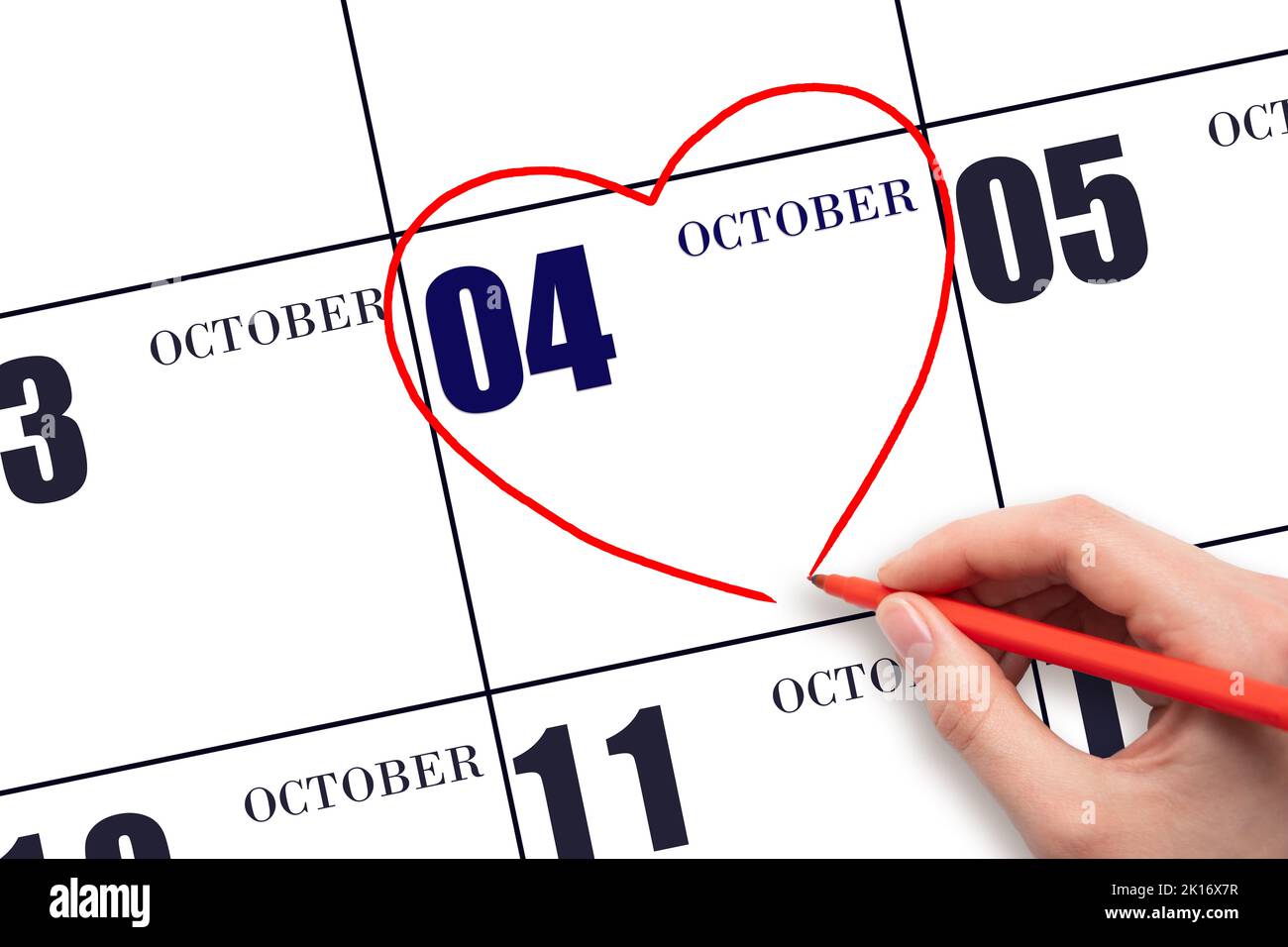 4th day of October. A woman's hand drawing a red heart shape on the ...