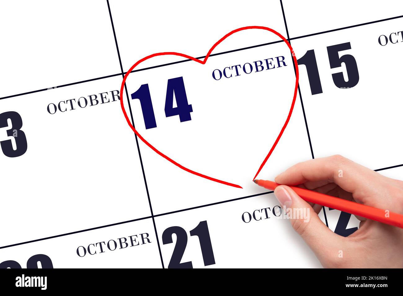 14th day of October. A woman's hand drawing a red heart shape on the ...