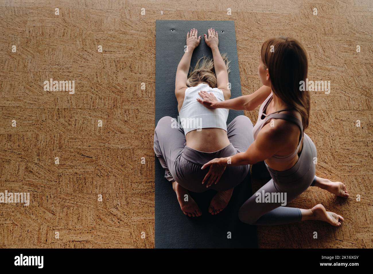 Yoga exercises. A personal trainer teaches a woman yoga classes in the ...