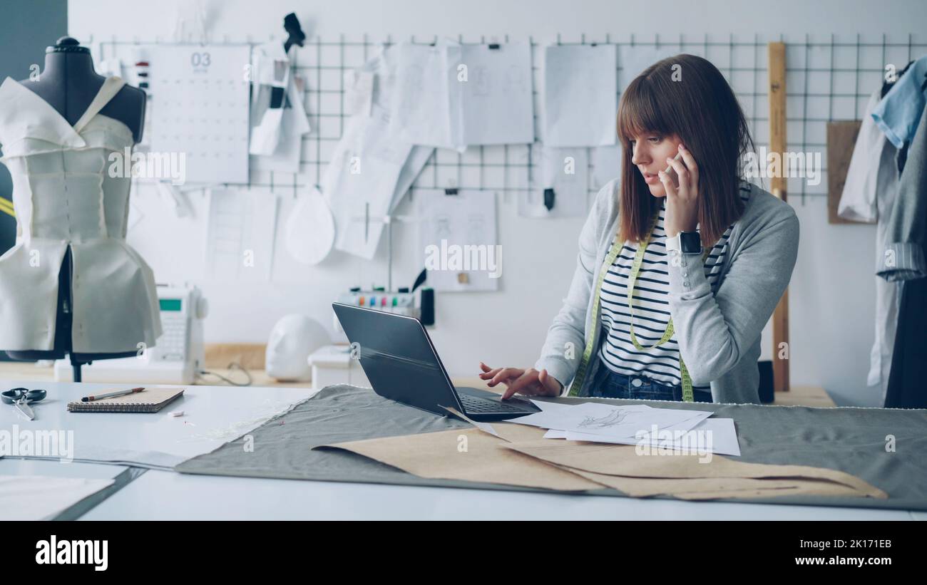 Confident clothing designer is discussing garment sketches on mobile ...