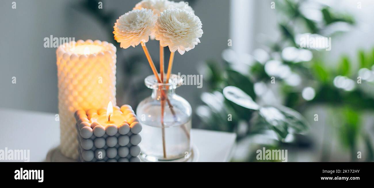 Home aroma fragrance diffuser and burning candles on bedside table in ...