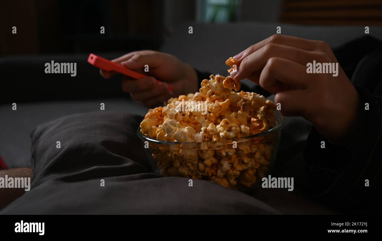 Close up view man hand grabbing popcorn and watching television at ...