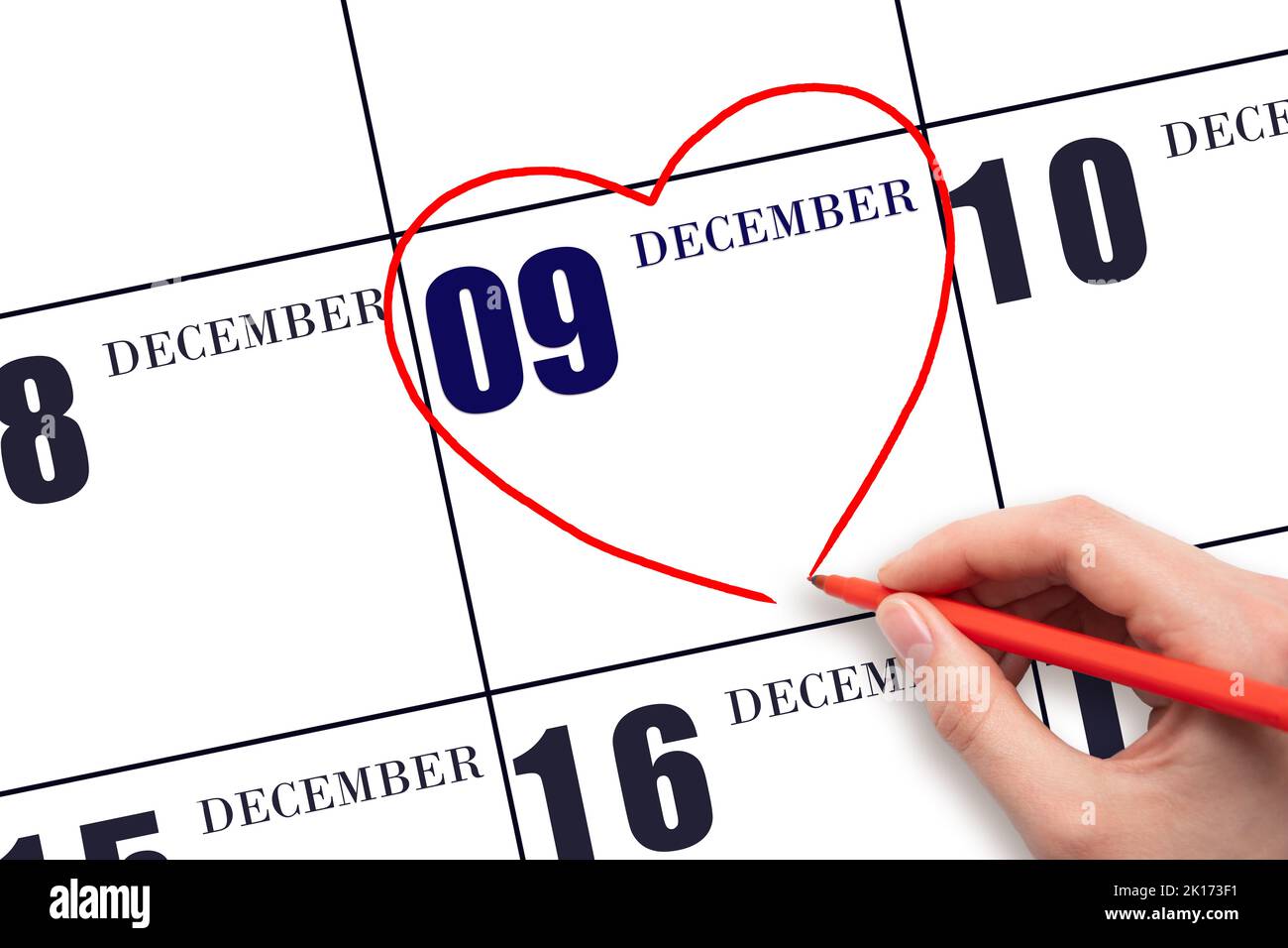 9th day of December. A woman's hand drawing a red heart shape on the ...