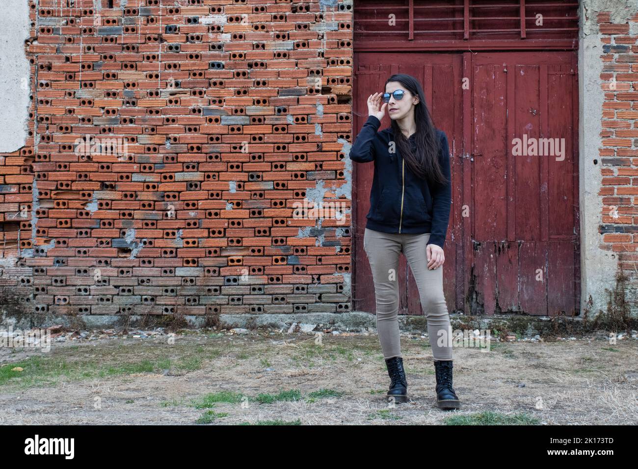 Women in front of brick wall and red door waiting Stock Photo - Alamy