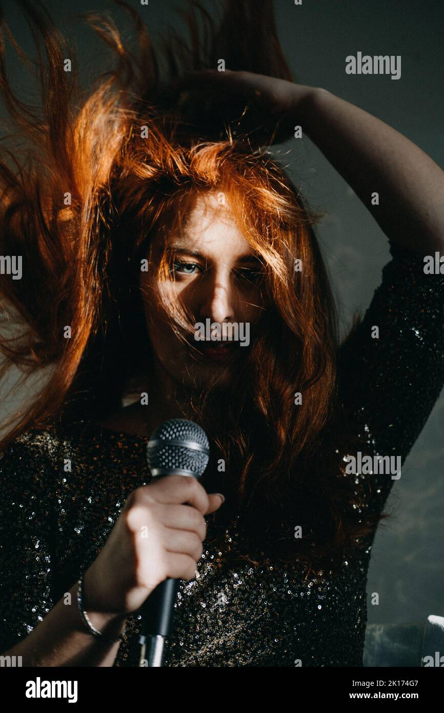 Portrait of redhead female singer woman in sparkly evening dress ...