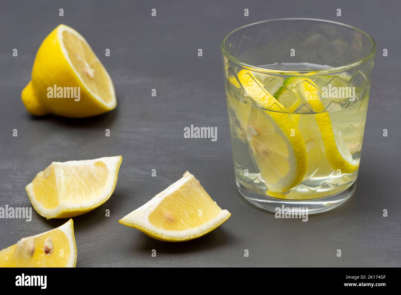 Glass with summer lemon drink. Lemon slices on table. Top view. Grey ...