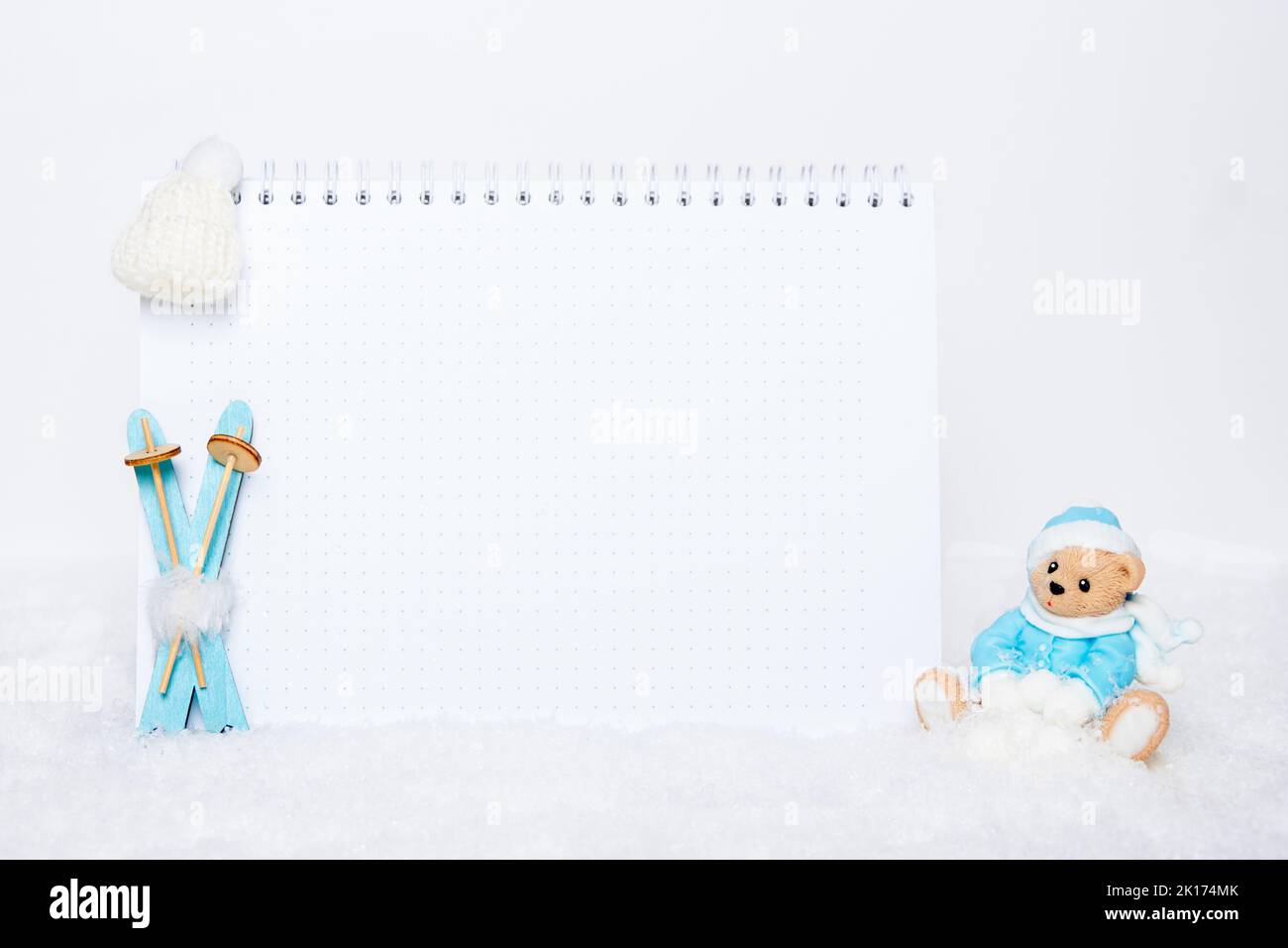 Time for winter holidays. Blank notepad, teddy bear with snowballs, toy ...