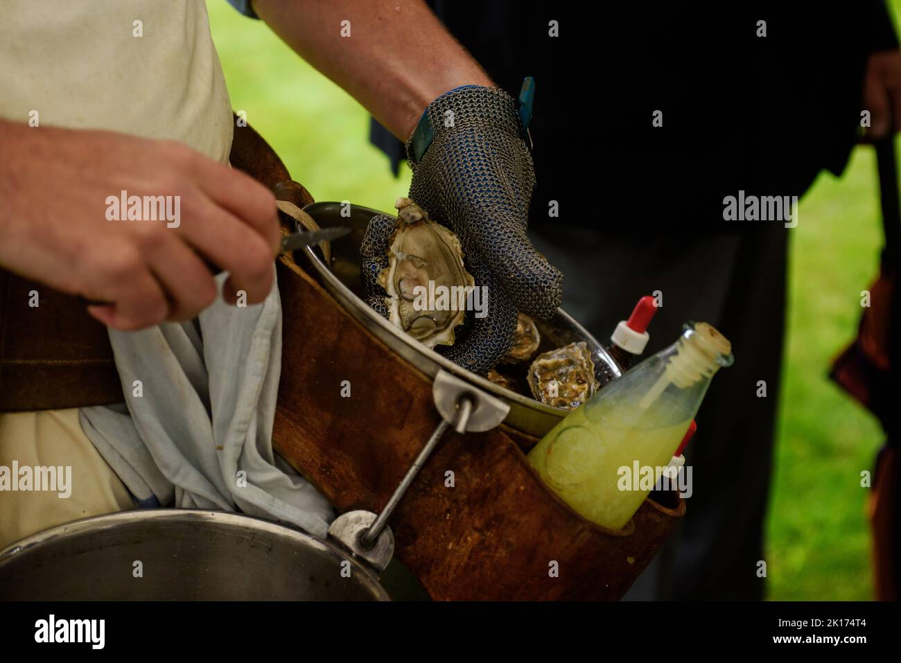 closeup of the hand of a man with a chainmail glove chucking an oyster ...