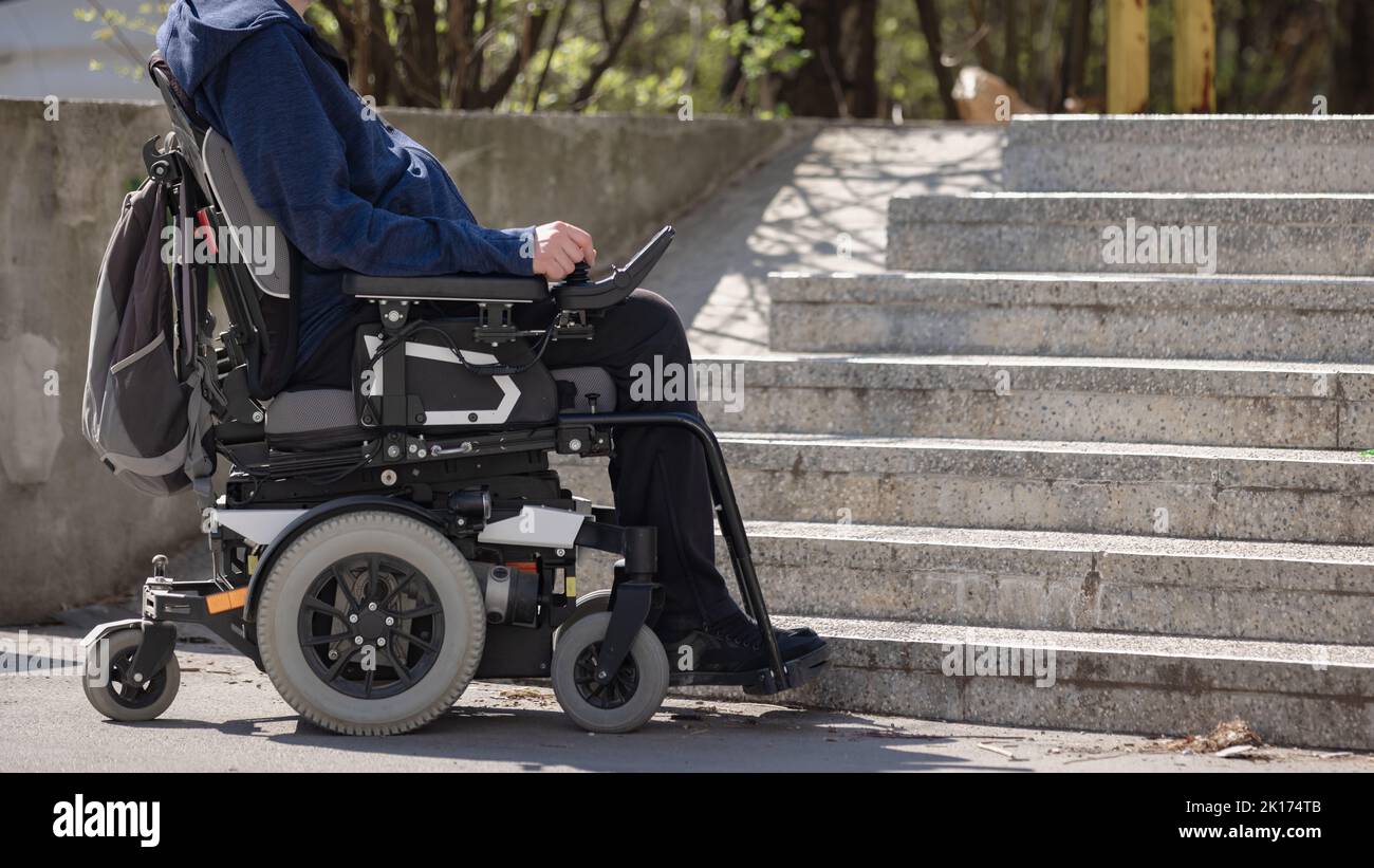 Person with disability on electric wheelchair stopping at the bottom of ...