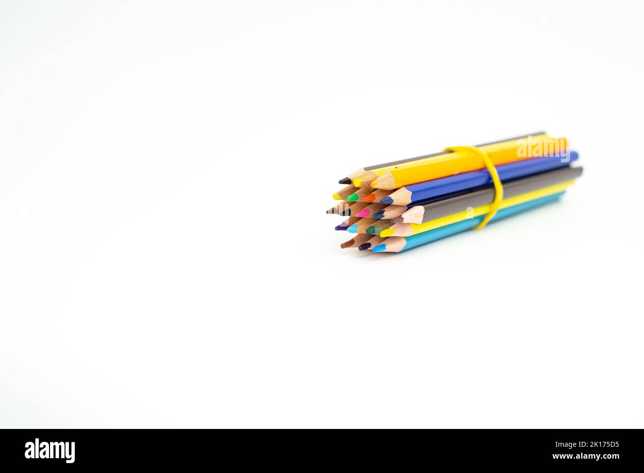 Wooden colored pencils gathered in a bundle with a rubber band on a ...