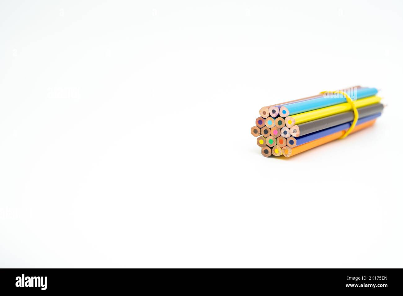 wooden colored pencils gathered in a bundle with a rubber band on a ...