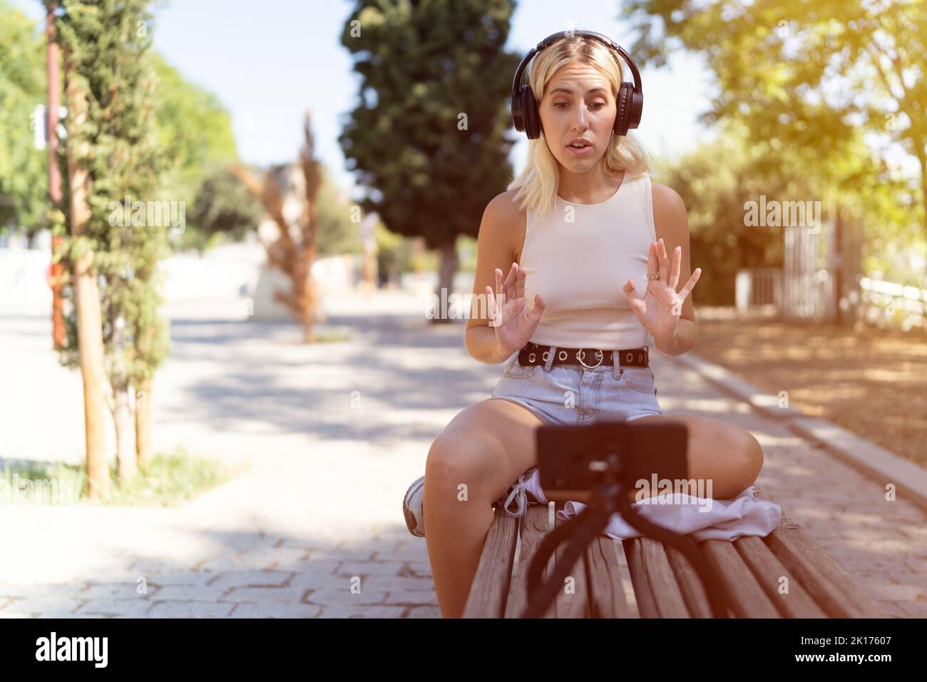 Influencer broadcasting live to her followers from a park bench ...