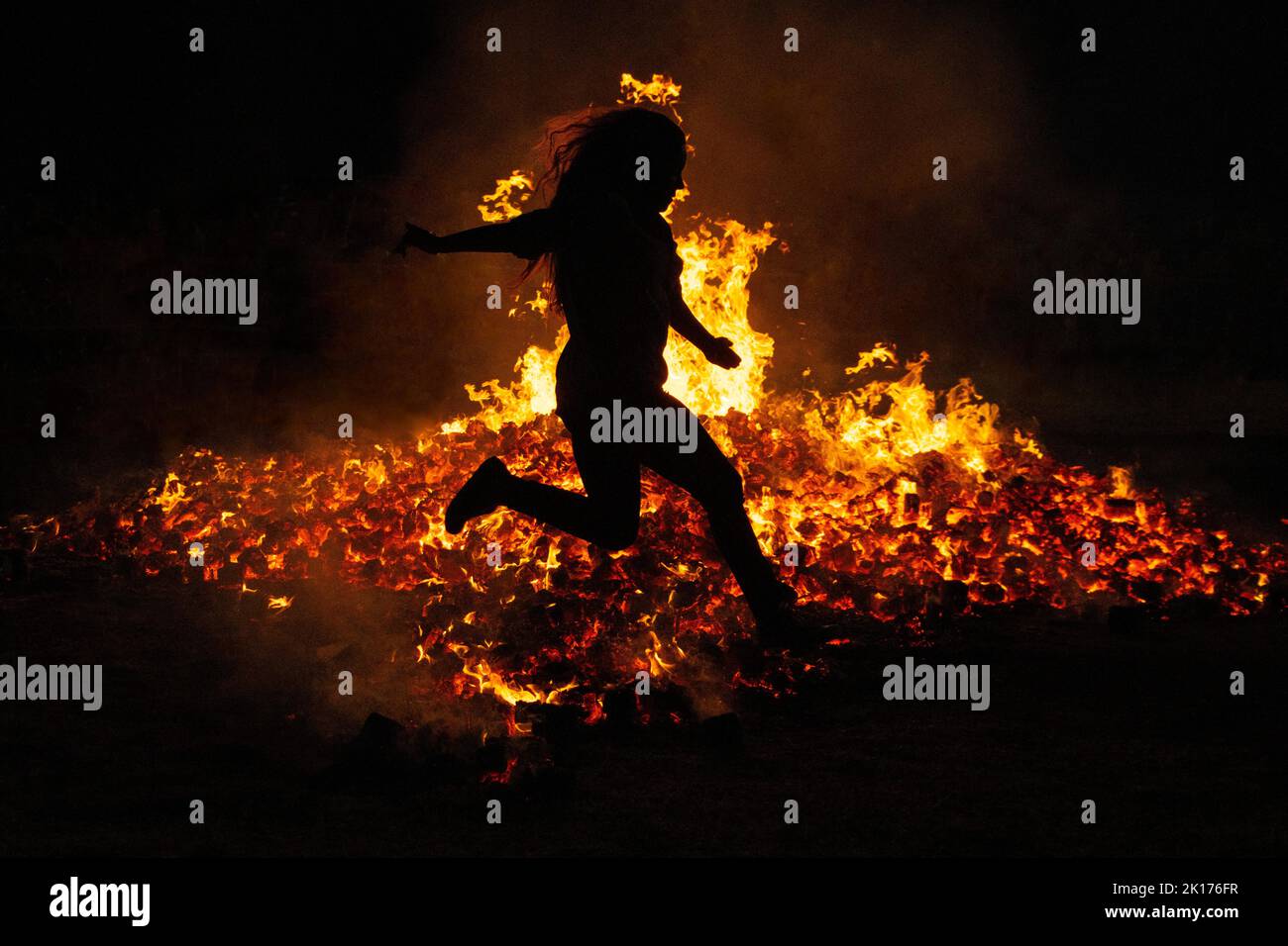 Summer solstice celebration jumping into the fire. Burning flames ...