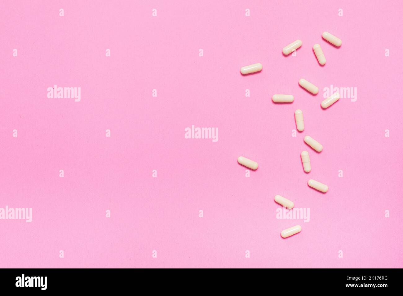 Tablets drugs therapy antibiotic on pastel pink background from above ...