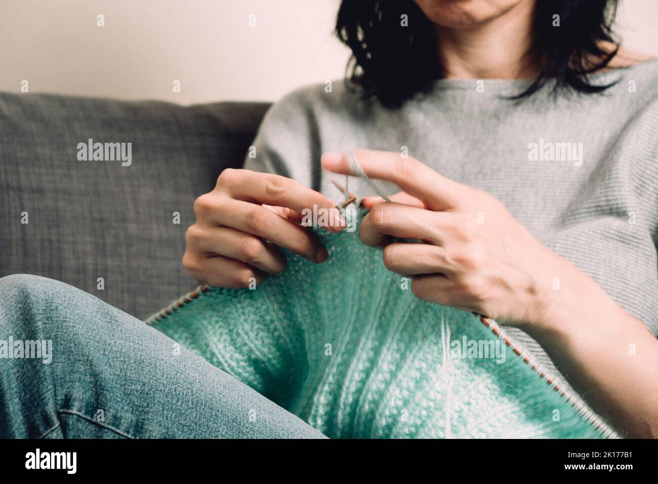 Close up of female hands holding bamboo knitting needles and knitting ...