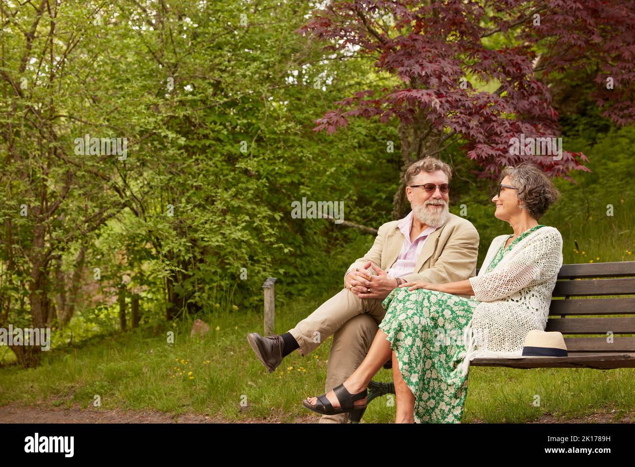 Couple sitting on bench together Stock Photo - Alamy