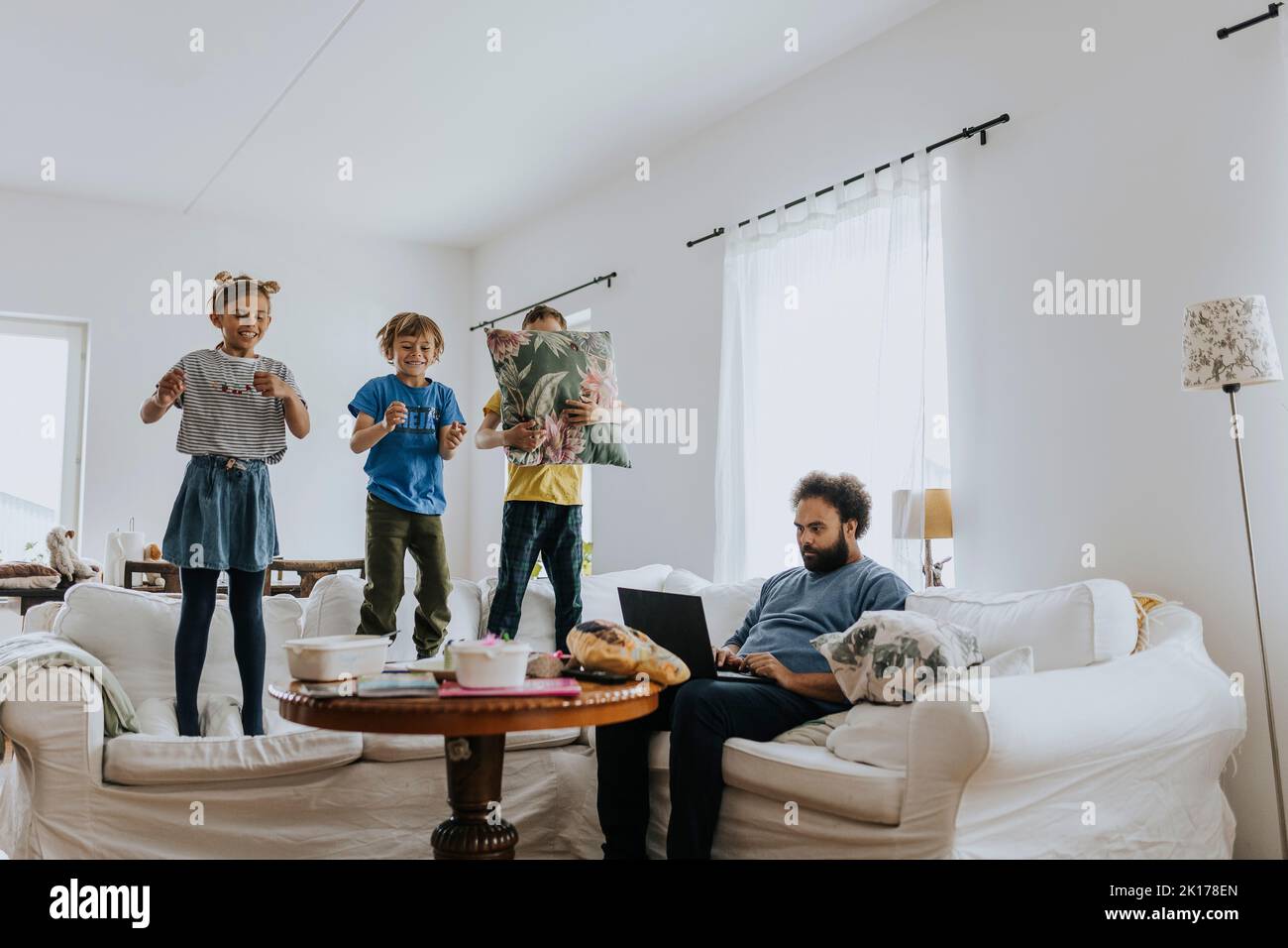 Man working from home and taking care of children Stock Photo - Alamy