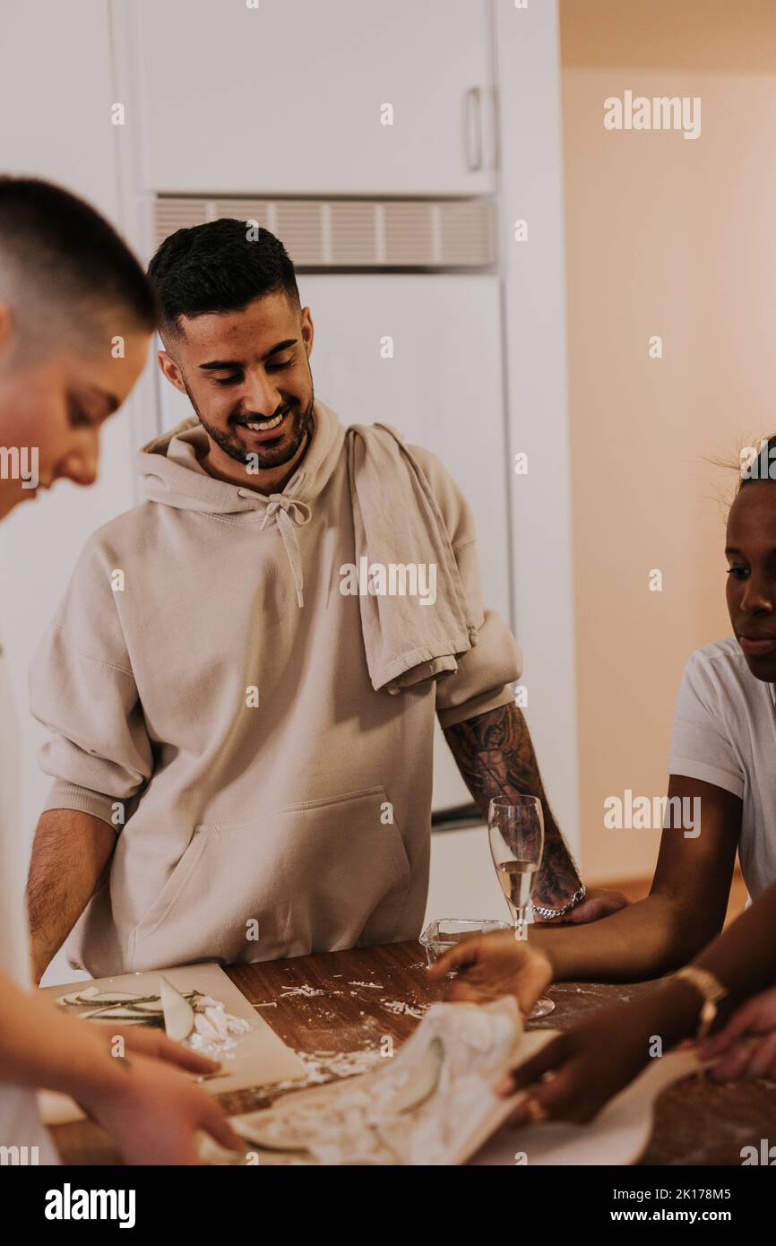 Friends preparing pizza at home Stock Photo - Alamy