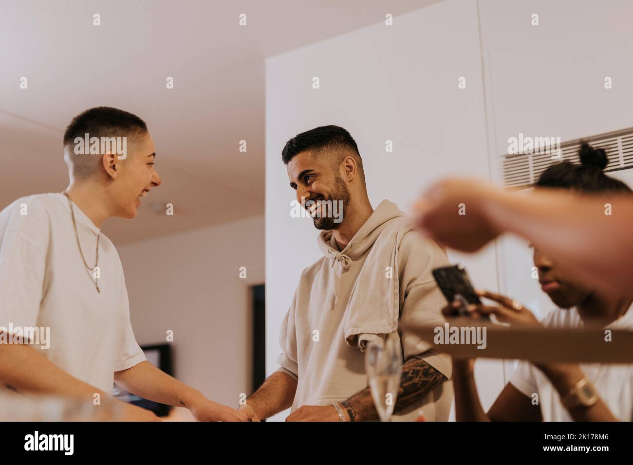 Happy friends talking during meeting Stock Photo - Alamy