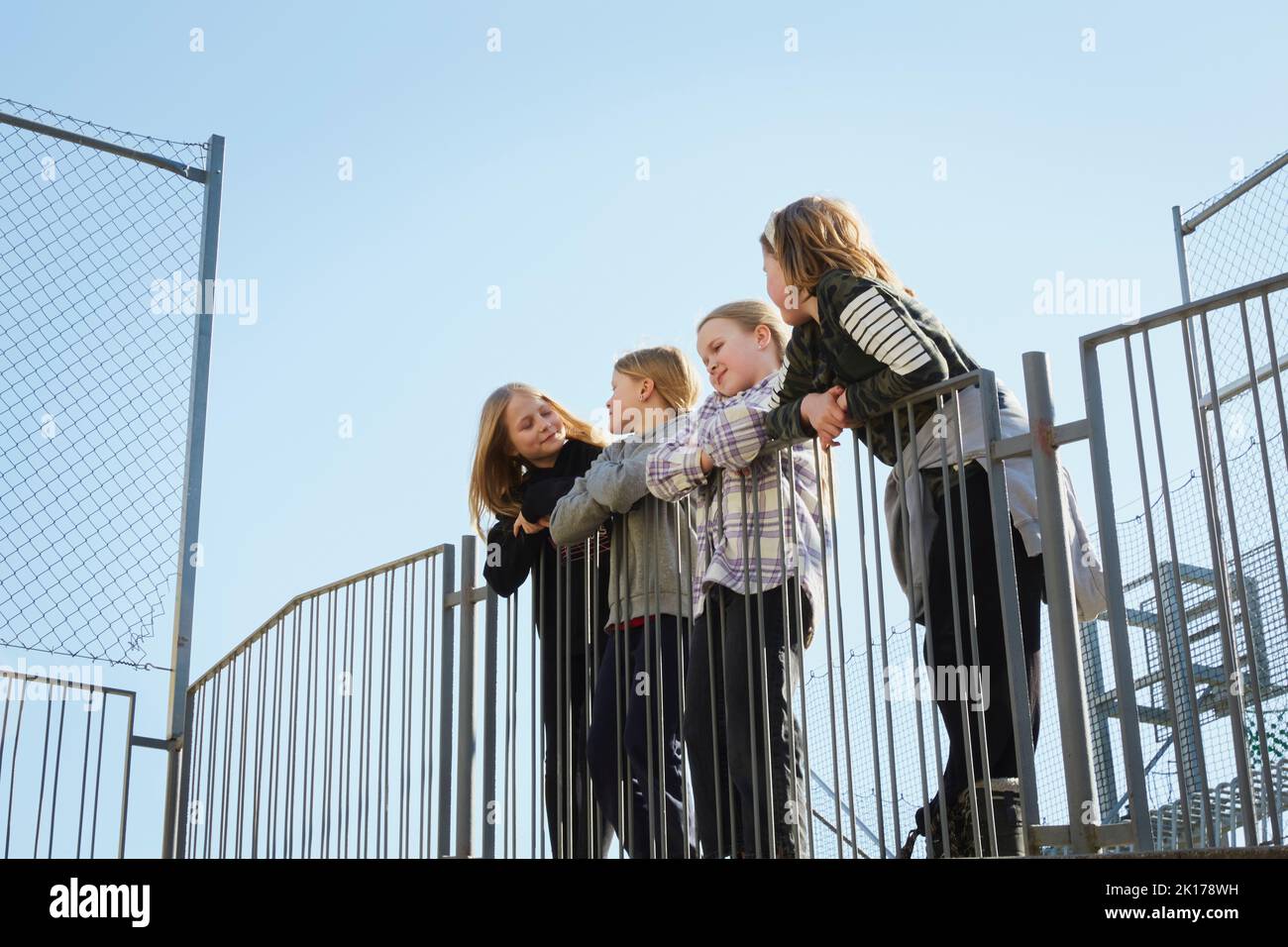 Children leaning against railing Stock Photo - Alamy