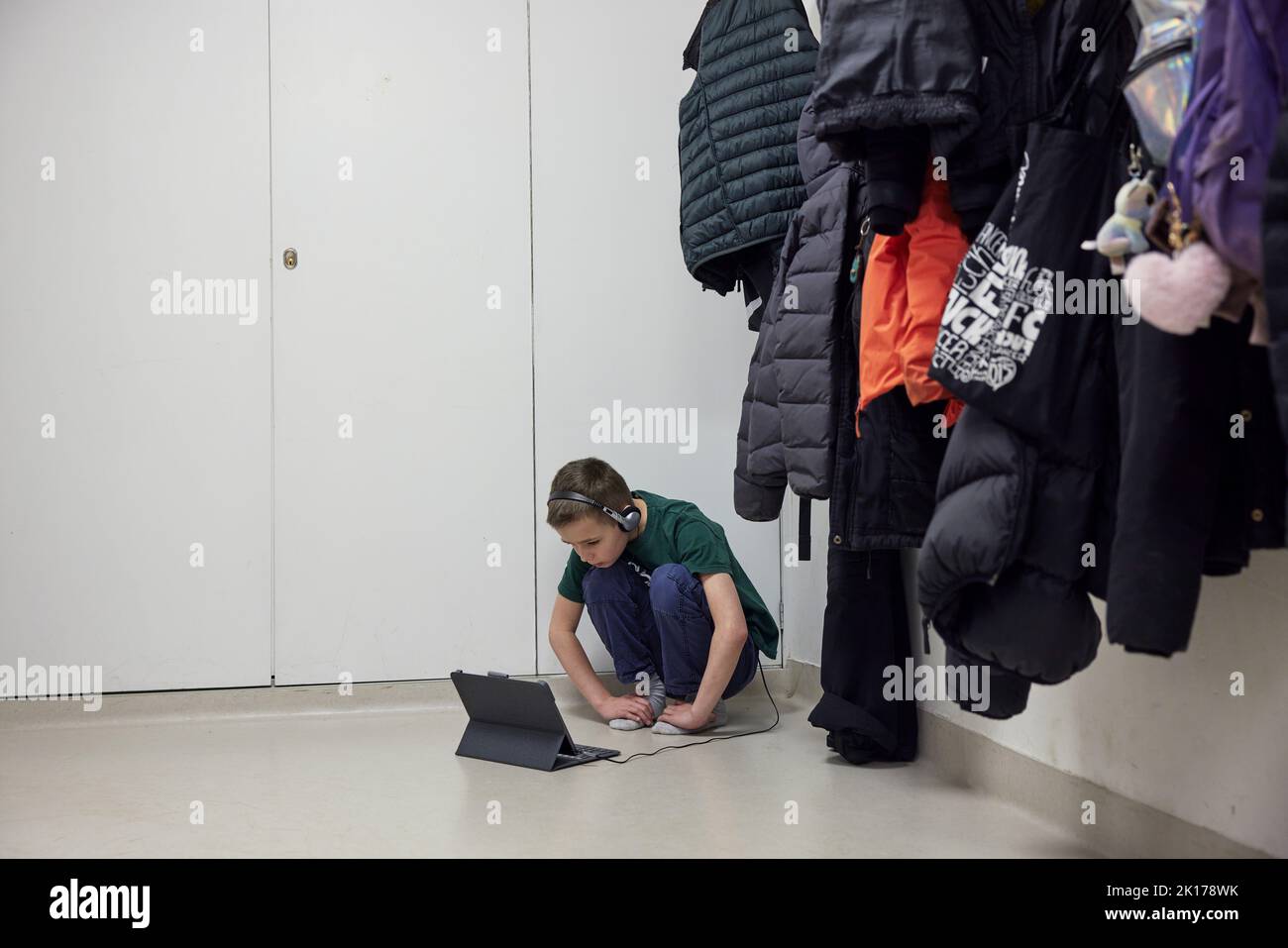 Boy using digital tablet in changing room Stock Photo - Alamy