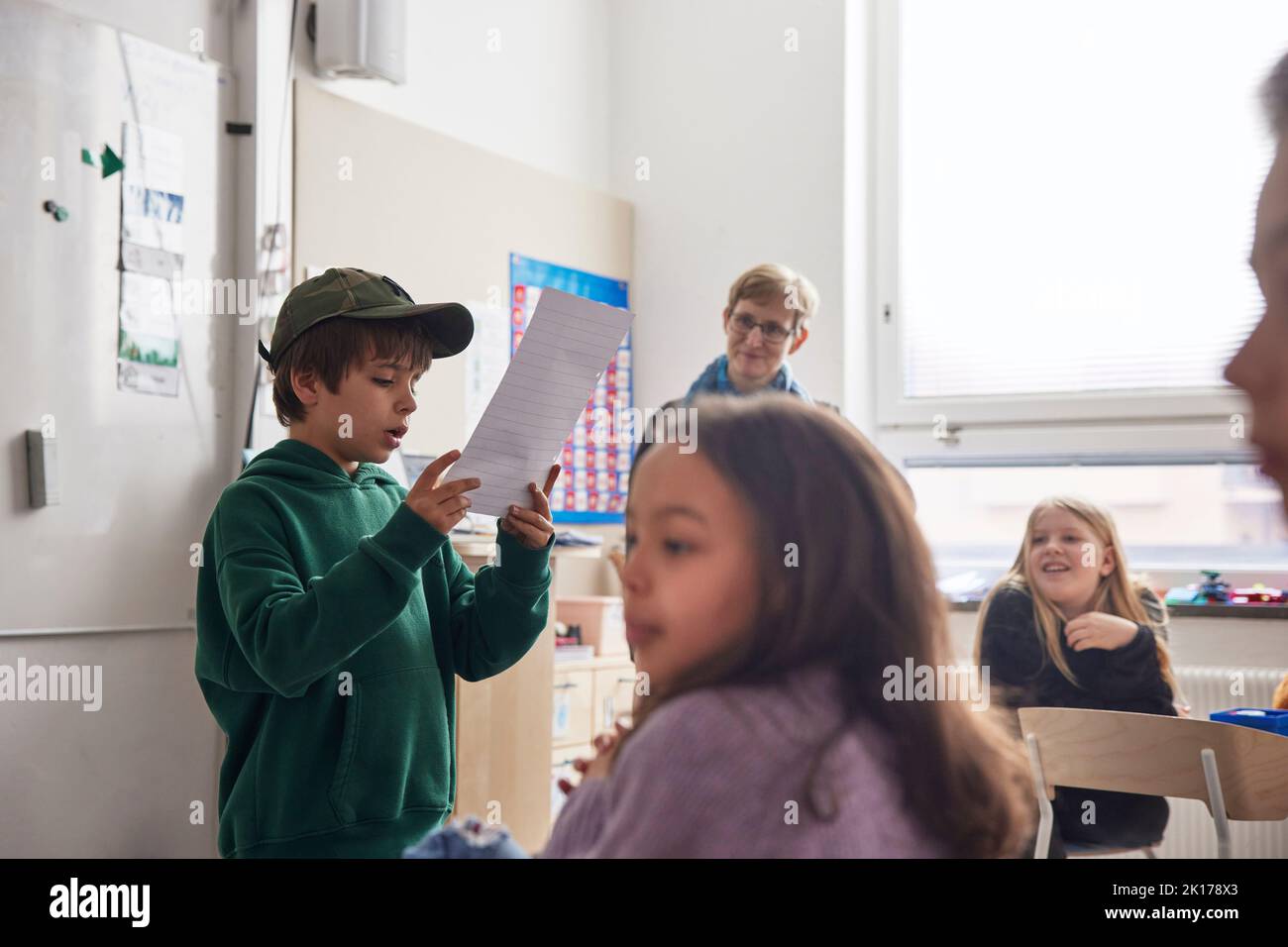 Boy reading in front of class Stock Photo - Alamy
