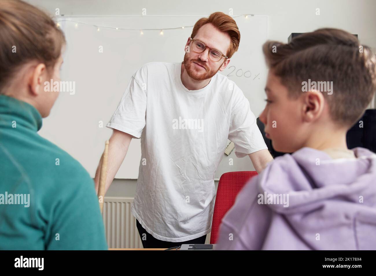 Teacher talking with children in classroom Stock Photo - Alamy