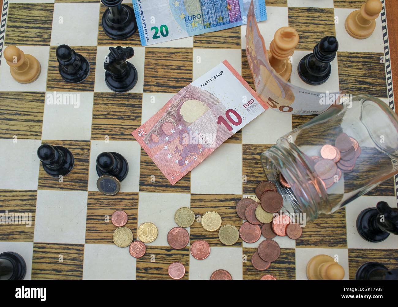 some bills and coins out of the glass jar and on the chessboard Stock ...