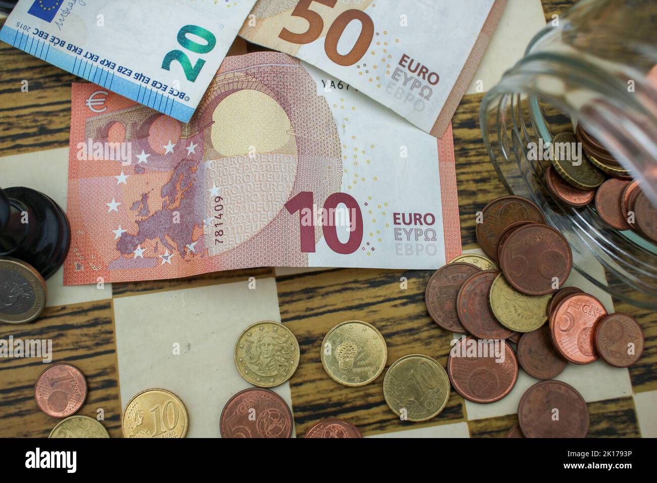 paper banknotes and metal coins on the chessboard Stock Photo - Alamy