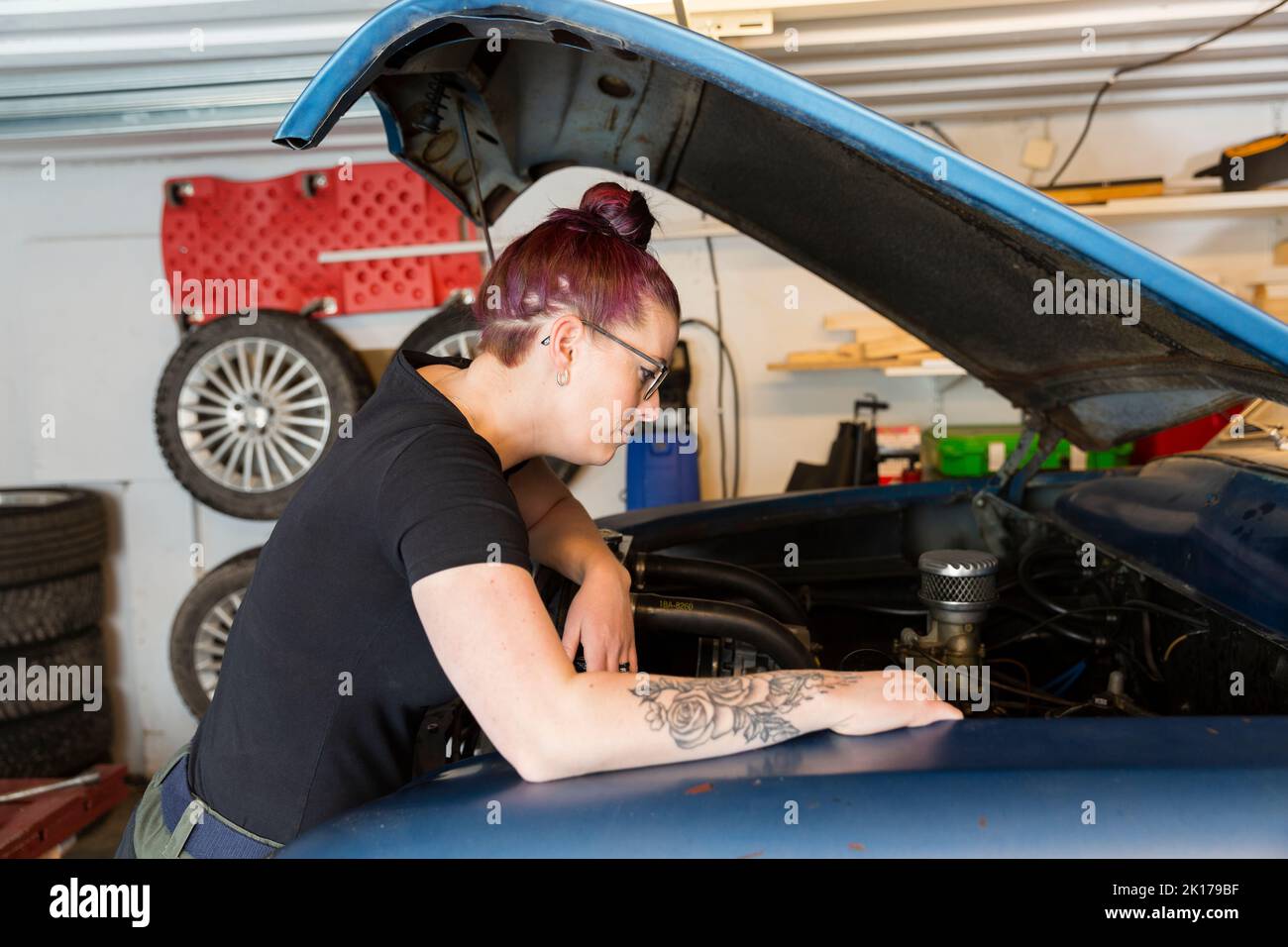 Woman repairing vintage car Stock Photo - Alamy