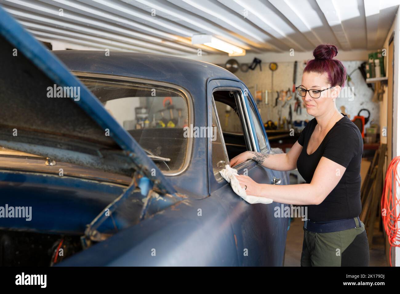 Woman repairing vintage car Stock Photo - Alamy