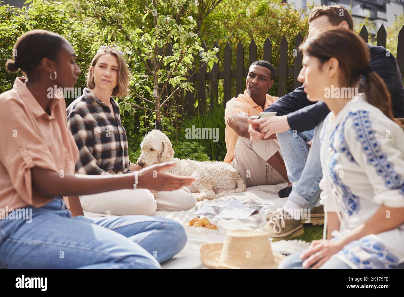 Friends sitting together in garden Stock Photo - Alamy
