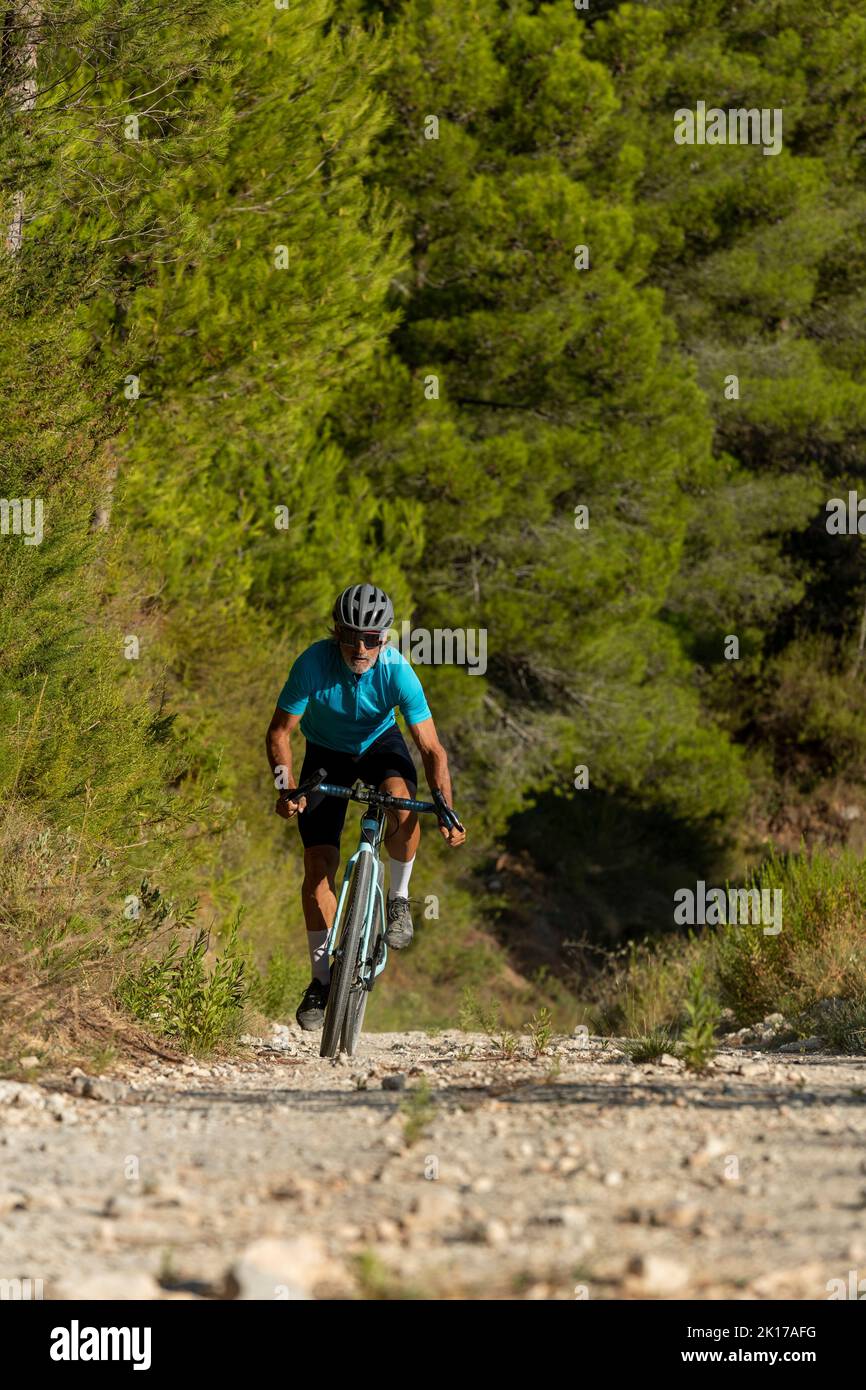 A male cyclist in a gravel road bicycle ride in the mountains of Costa ...