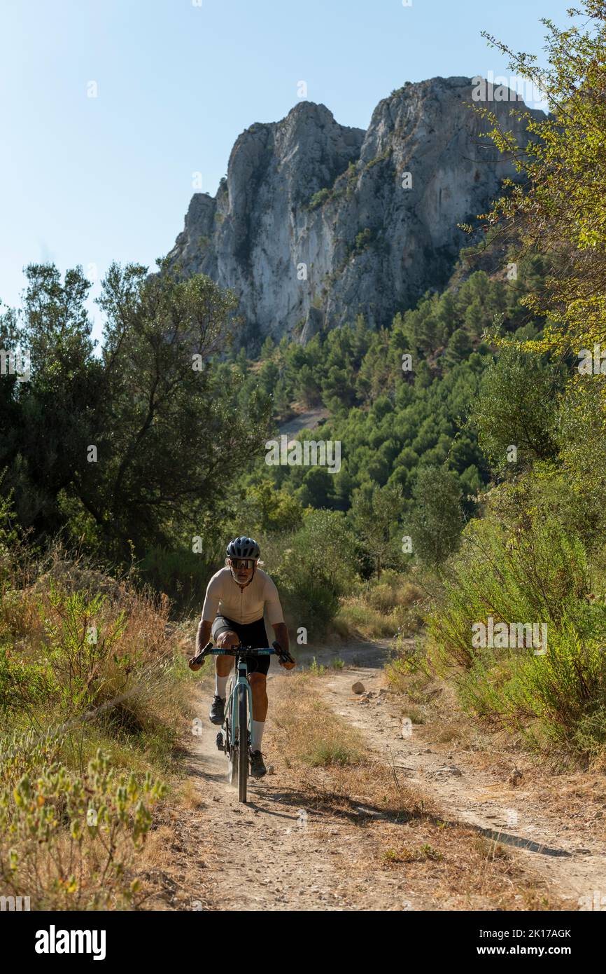 A male cyclist in a gravel road bicycle ride in the mountains of Costa ...